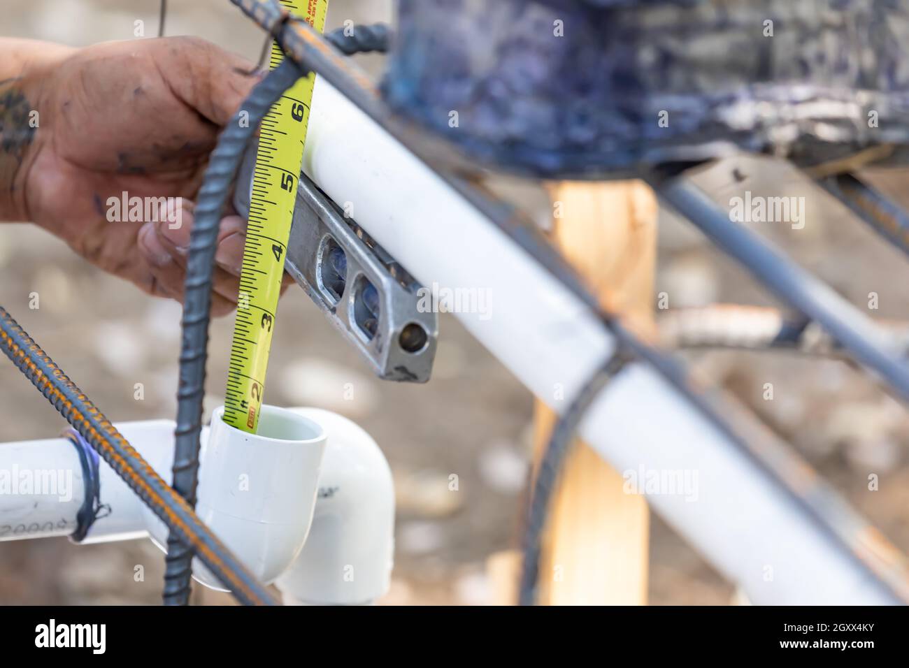 Plumber Using Level And Tape Measure While Installing PVC Pipe At ...