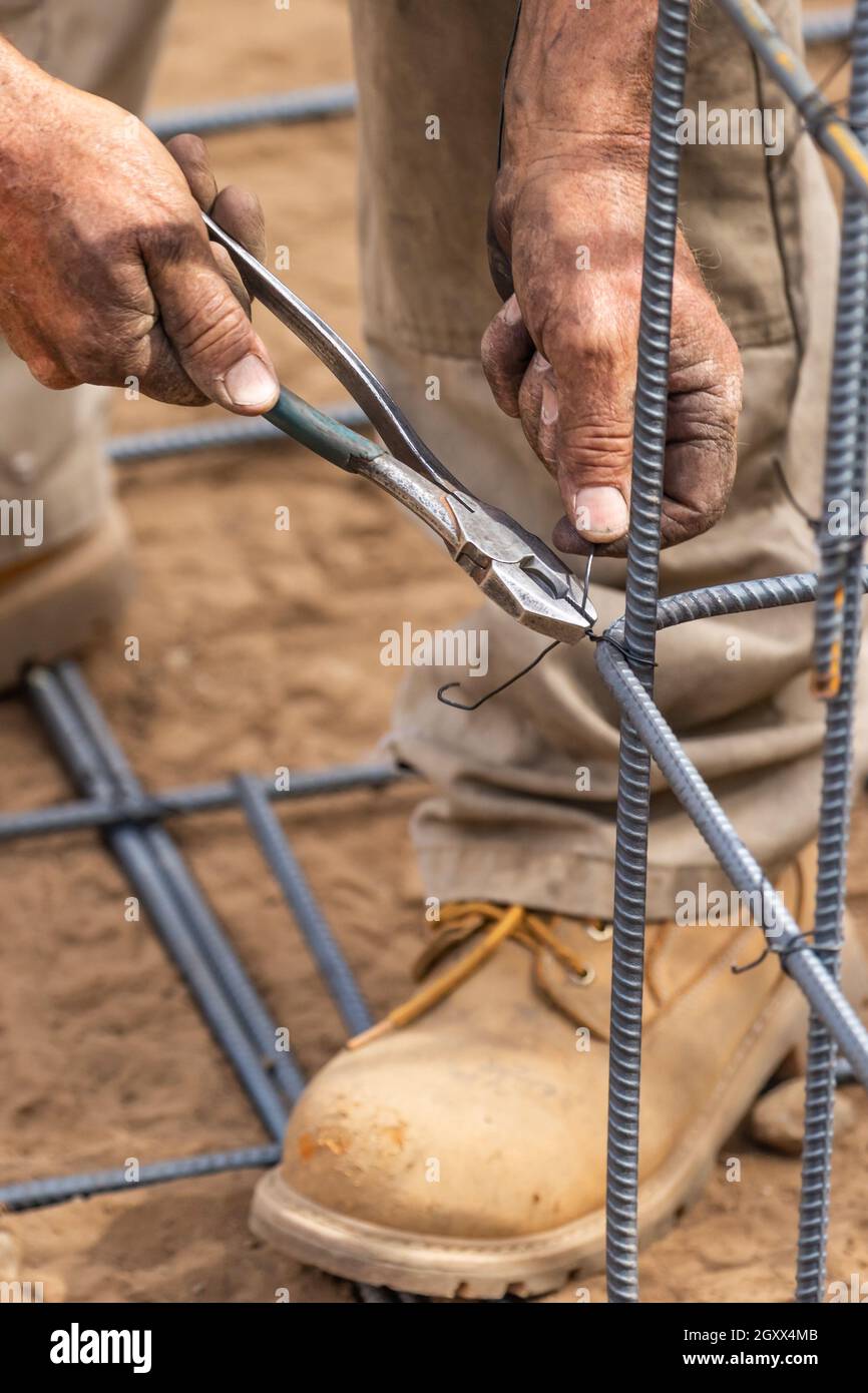 Worker Securing Steel Rebar Framing With Wire Plier Cutter Tool At ...