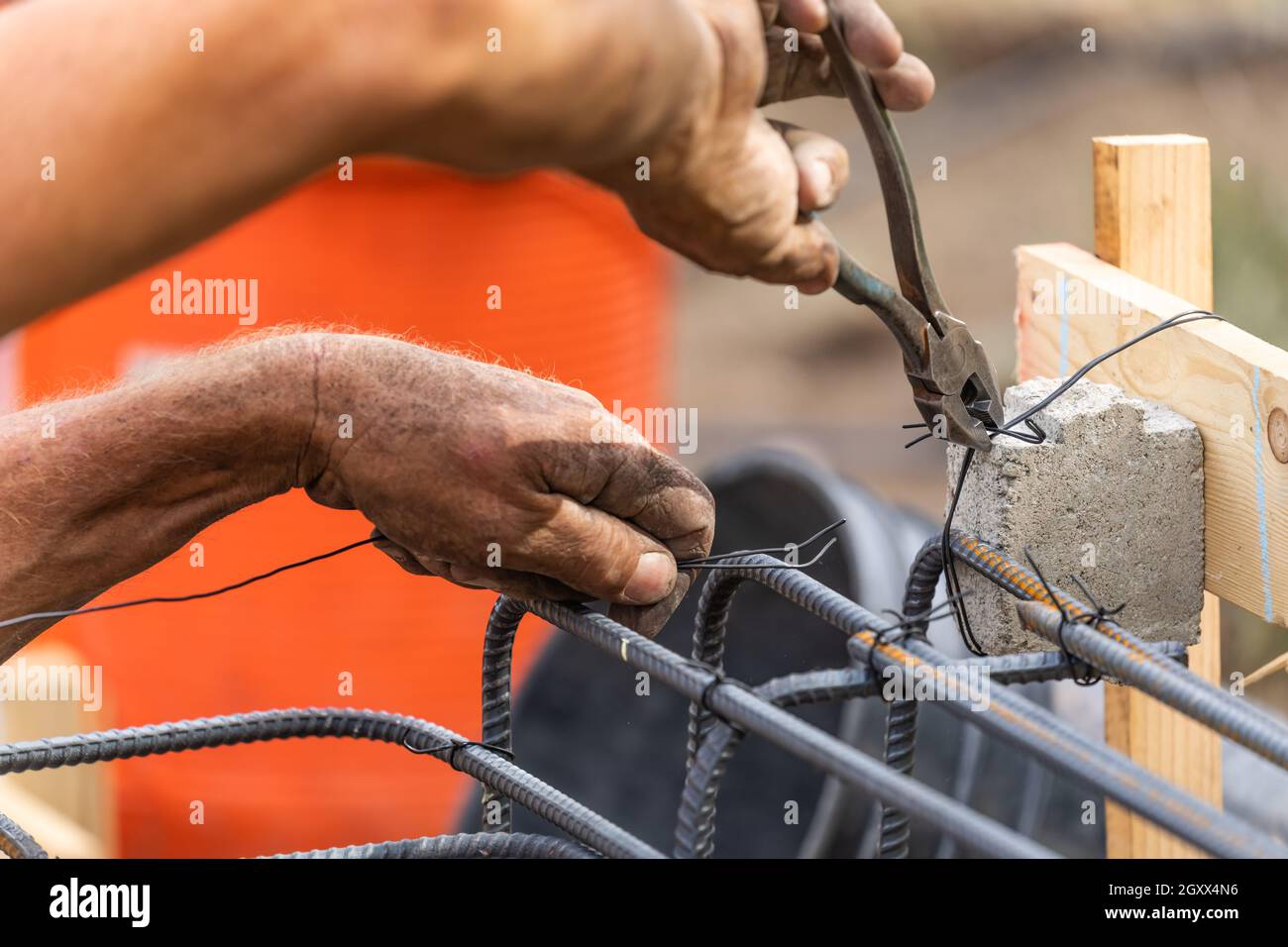 Worker Securing Steel Rebar Framing With Wire Plier Cutter Tool At ...