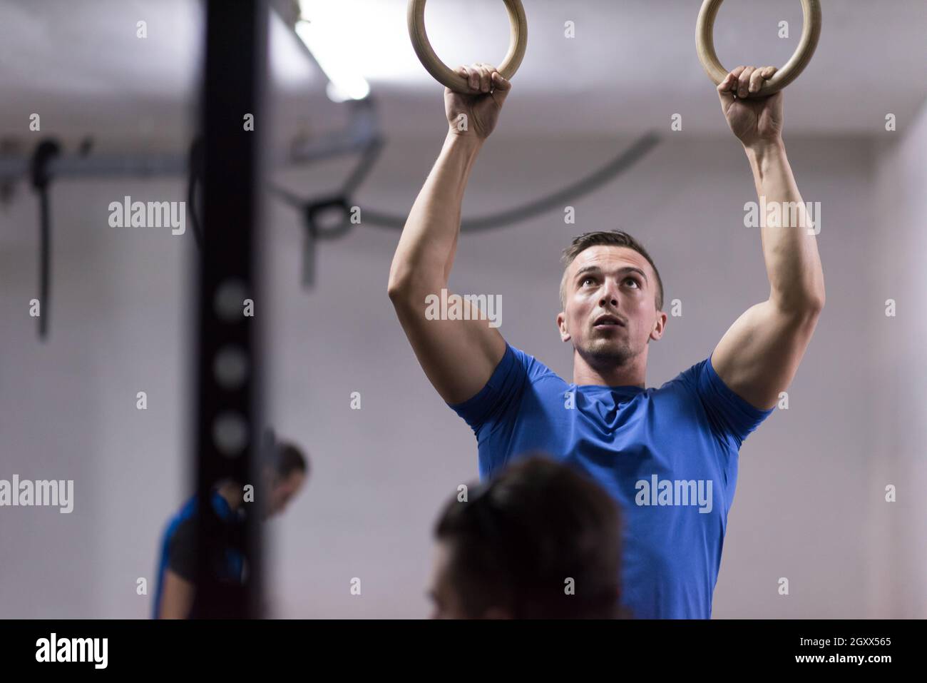 Fitness handsome man doing dipping exercise using rings in the gym ...