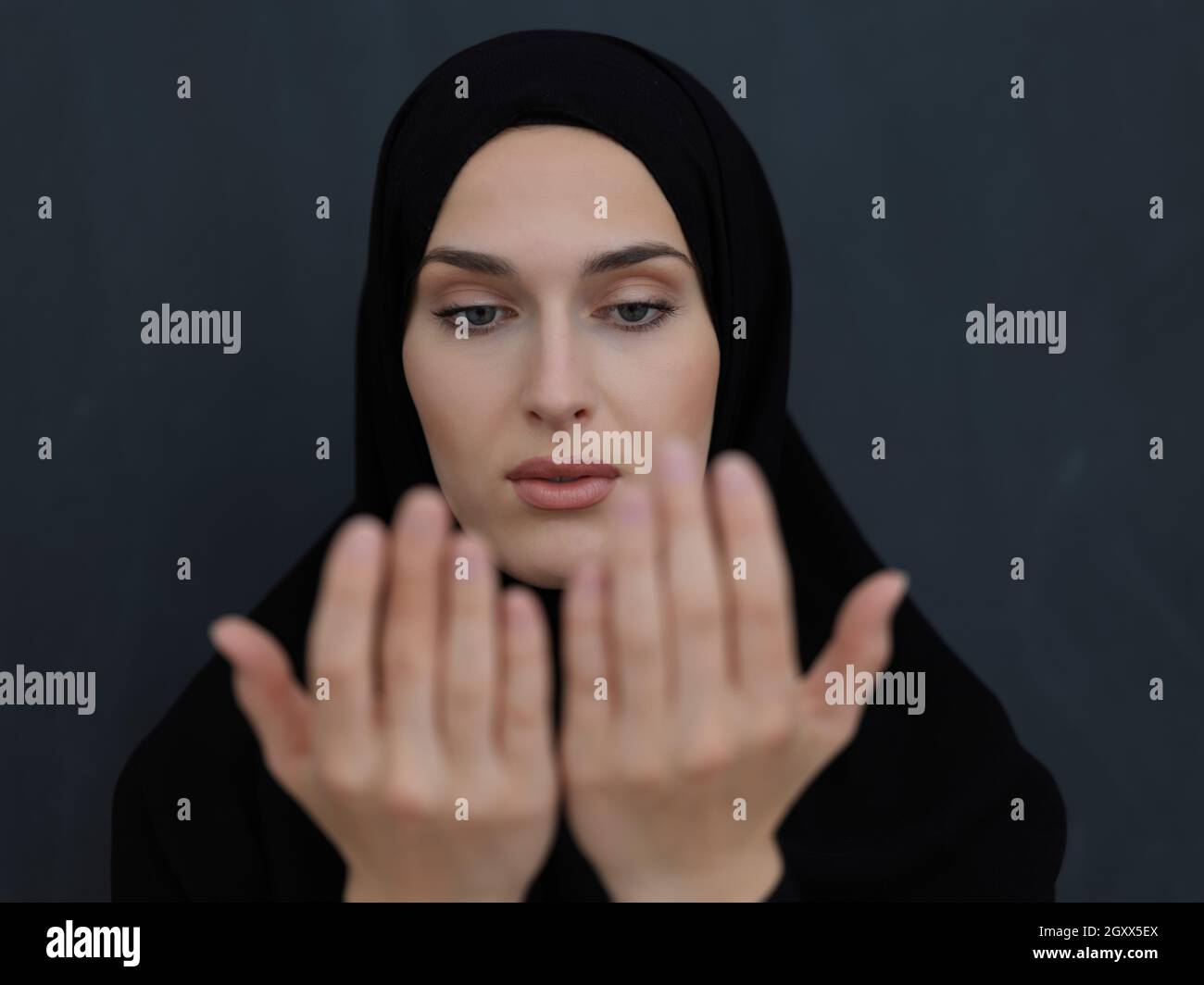 Portrait of young Muslim woman making dua. Arabian girl wearing abaya ...