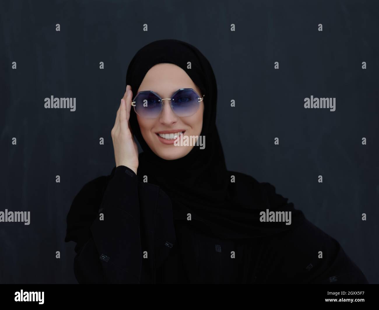 Young muslim in traditional clothes or abaya and sunglasses posing in ...