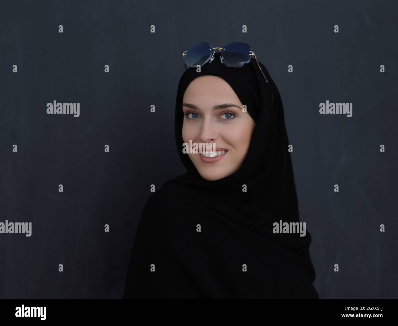 Young muslim in traditional clothes or abaya and sunglasses posing in ...