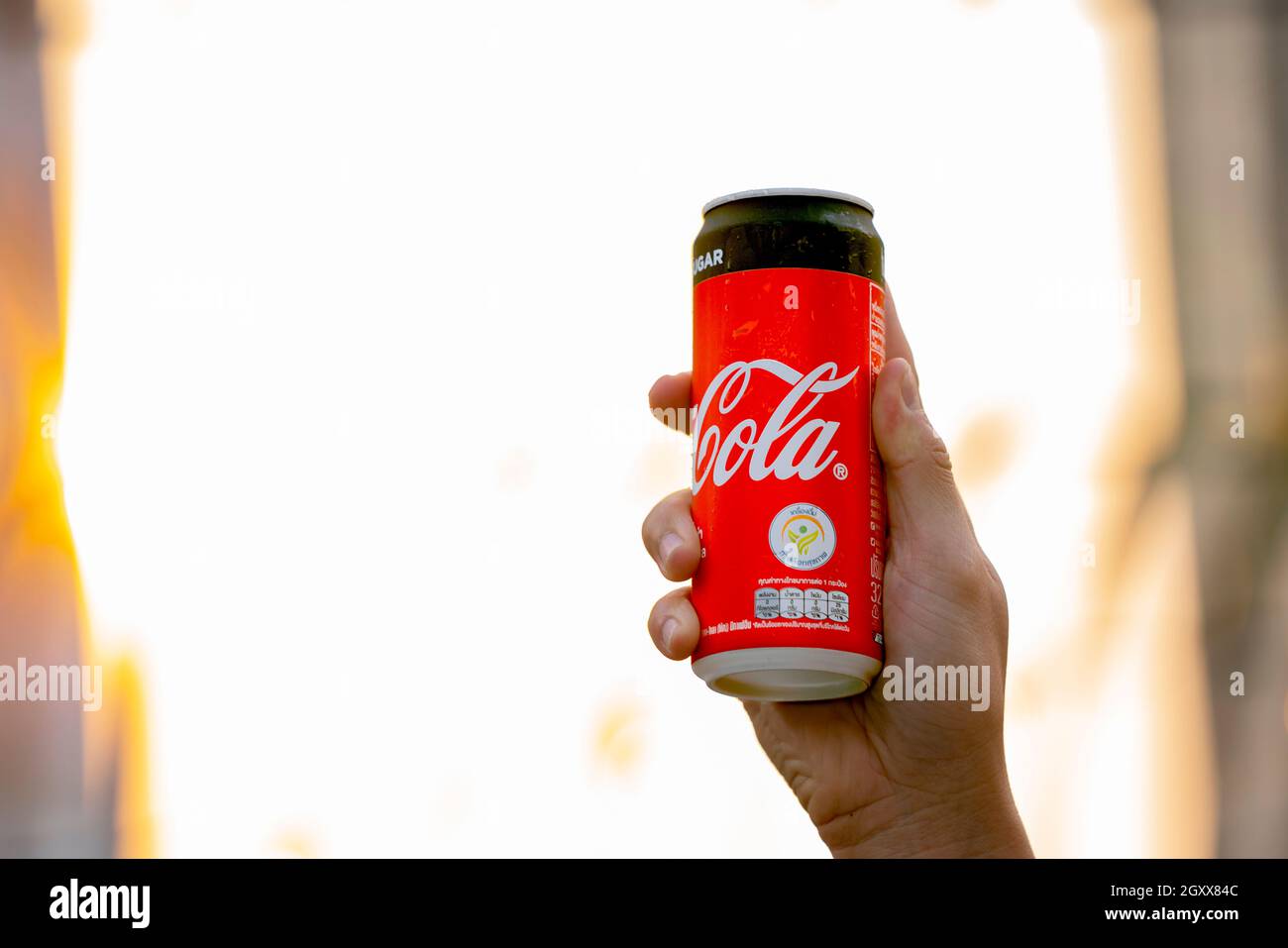 Coca Cola Drink in hand. Guy rising can to sunlight. Man holding and ...