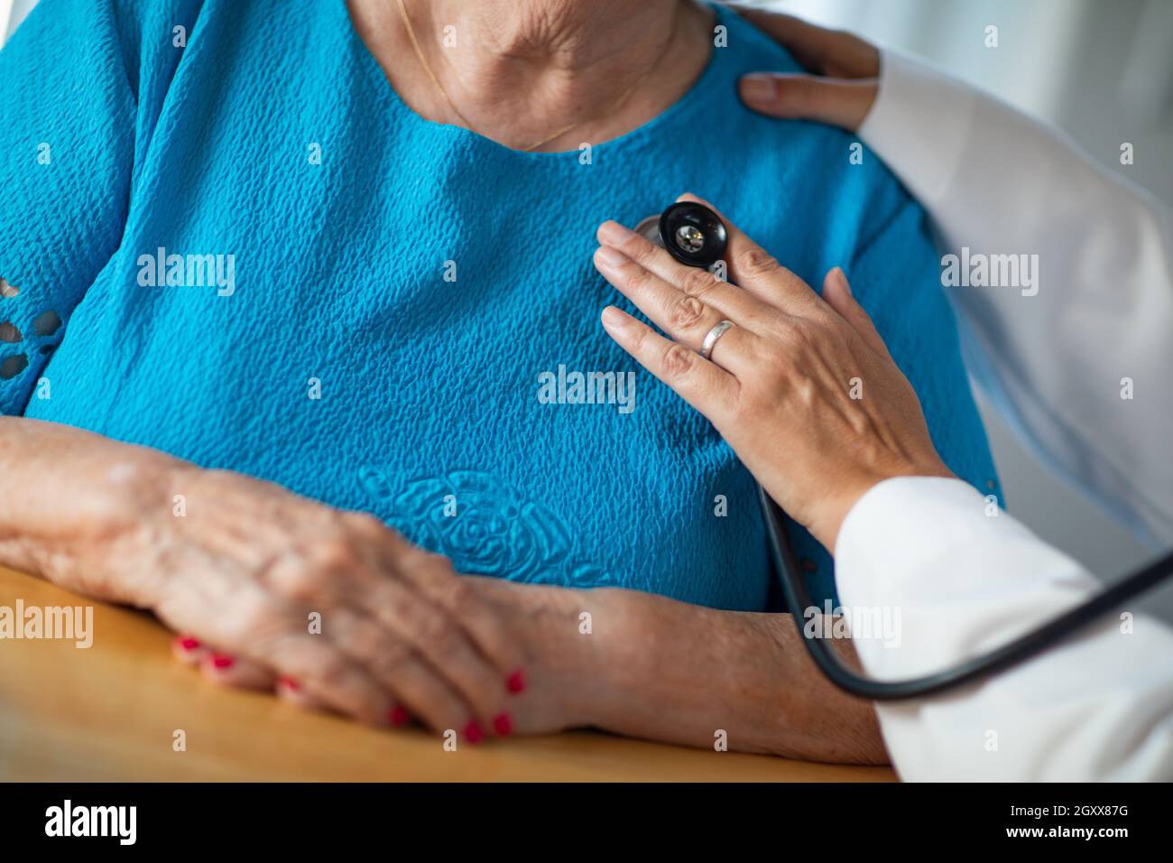 Female Doctor Checking The Heart With Stethoscope of Senior Adult Woman ...