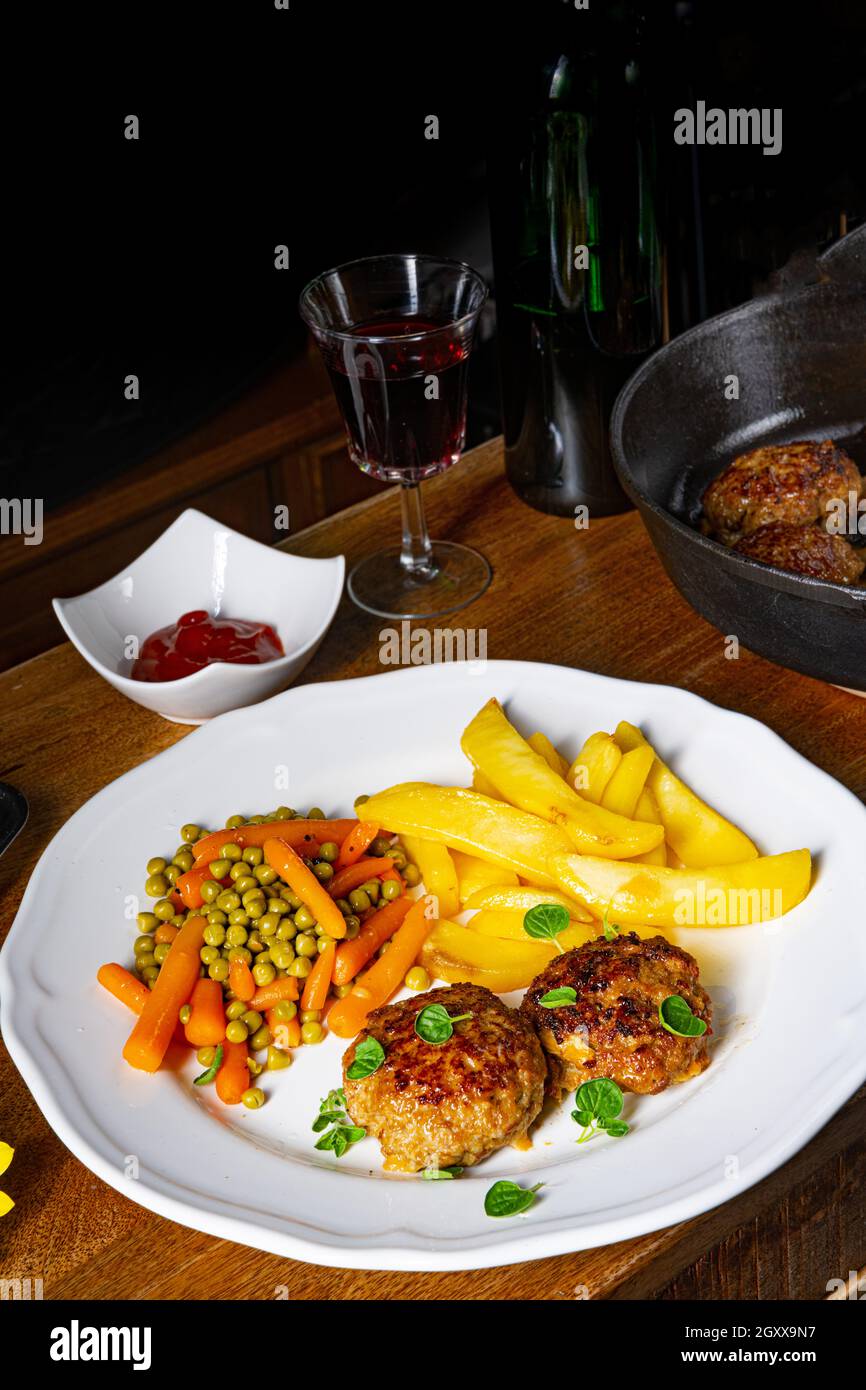 Homemade meatballs with french fries and vegetables Stock Photo - Alamy