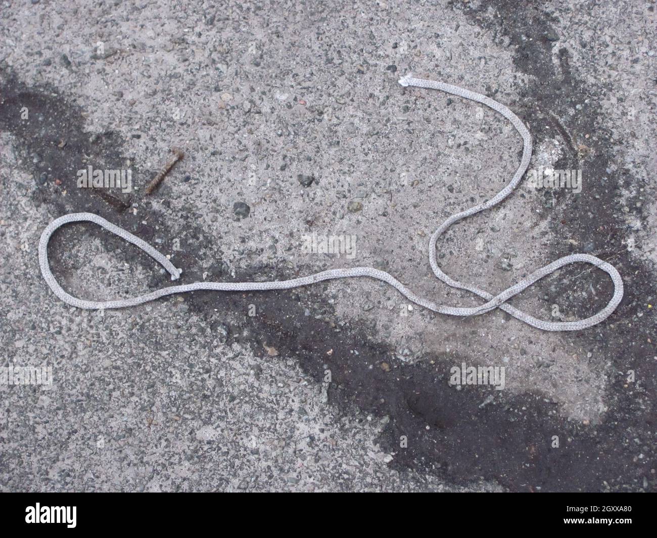 a shabby rope lying on the pavement Stock Photo - Alamy