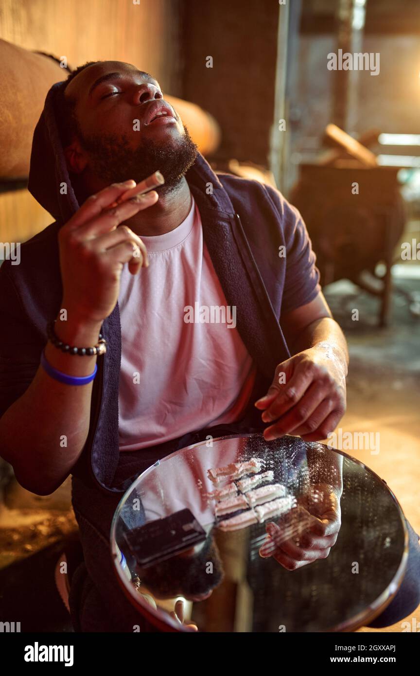 Drug addict man takes a dose of powder in hellhole, shebang interior on ...