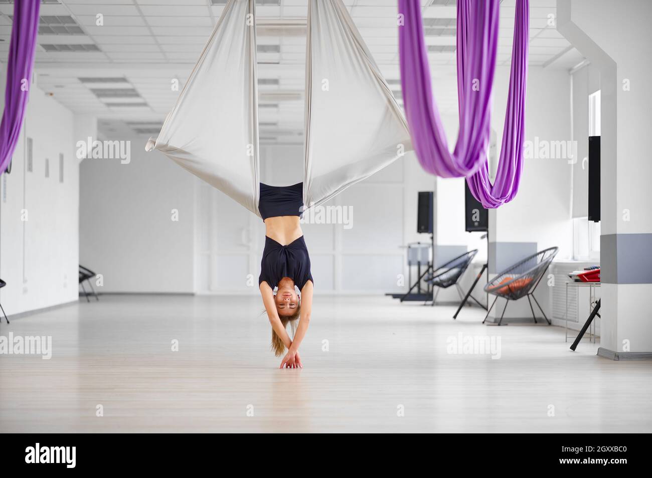 Aerial yoga, woman hanging upside down on hammock. Fitness, pilates and ...