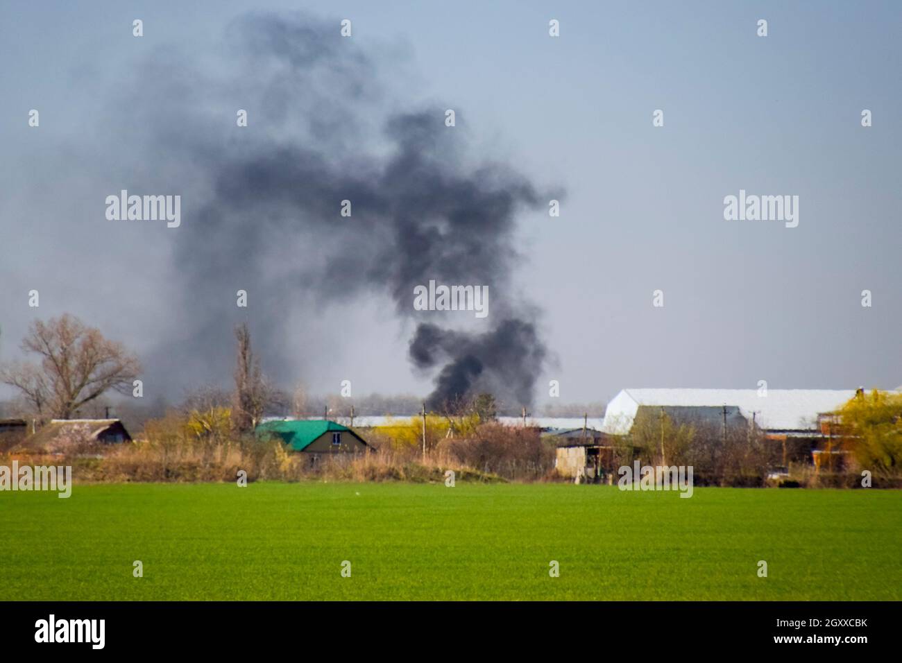 Fire and black smoke outside the village. Soot from burning Stock Photo ...