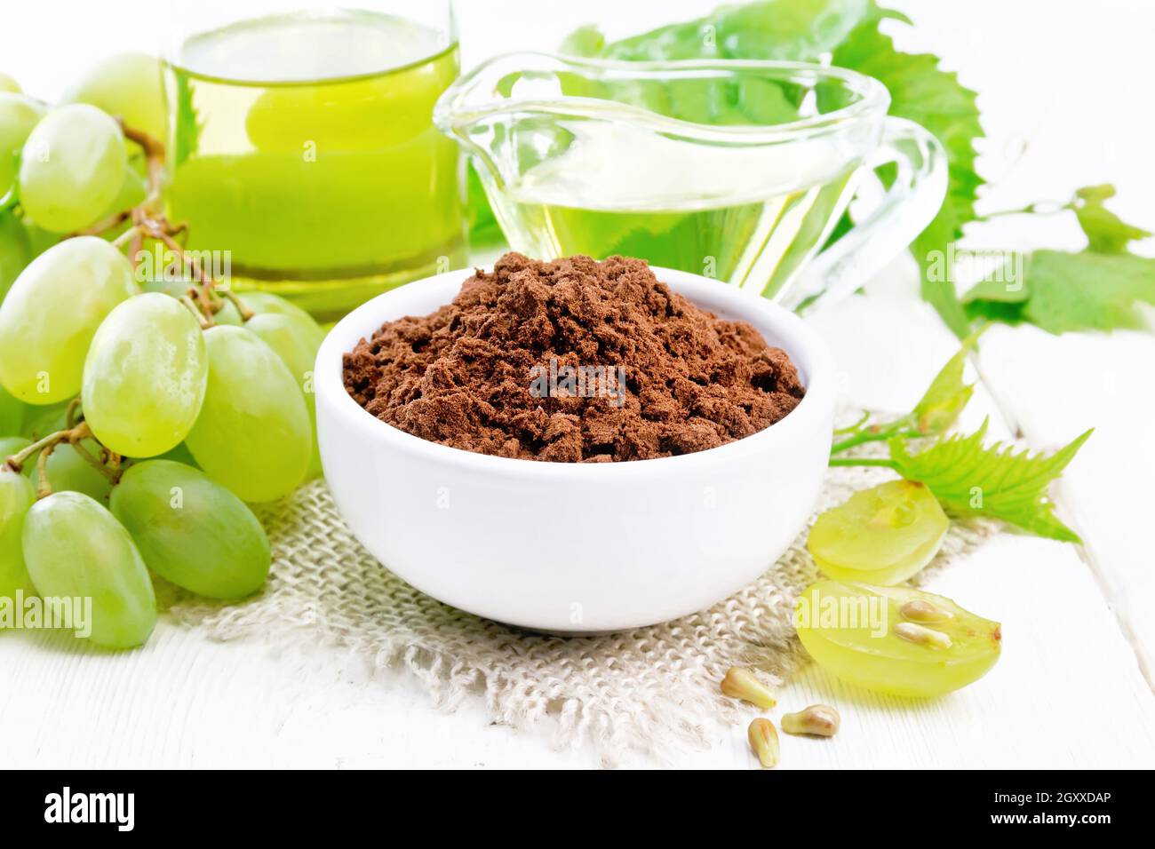 Grape seed flour in a bowl on sacking, oil in a jar and gravy boat ...