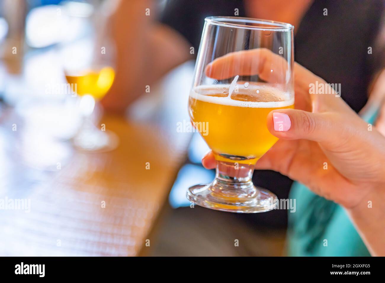 Female Hand Holding Glass of Micro Brew Beer At Bar Stock Photo - Alamy
