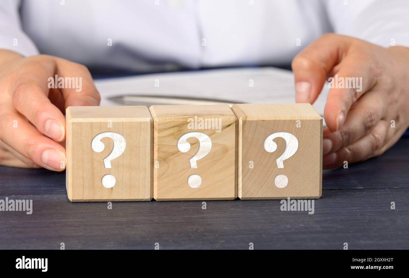 woman holding wooden cubes with question marks. Q&A concept, suspense ...