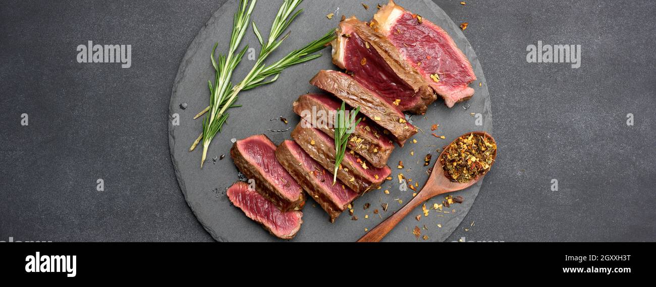 fried beef steaks cut into pieces on a black board, the degree of ...