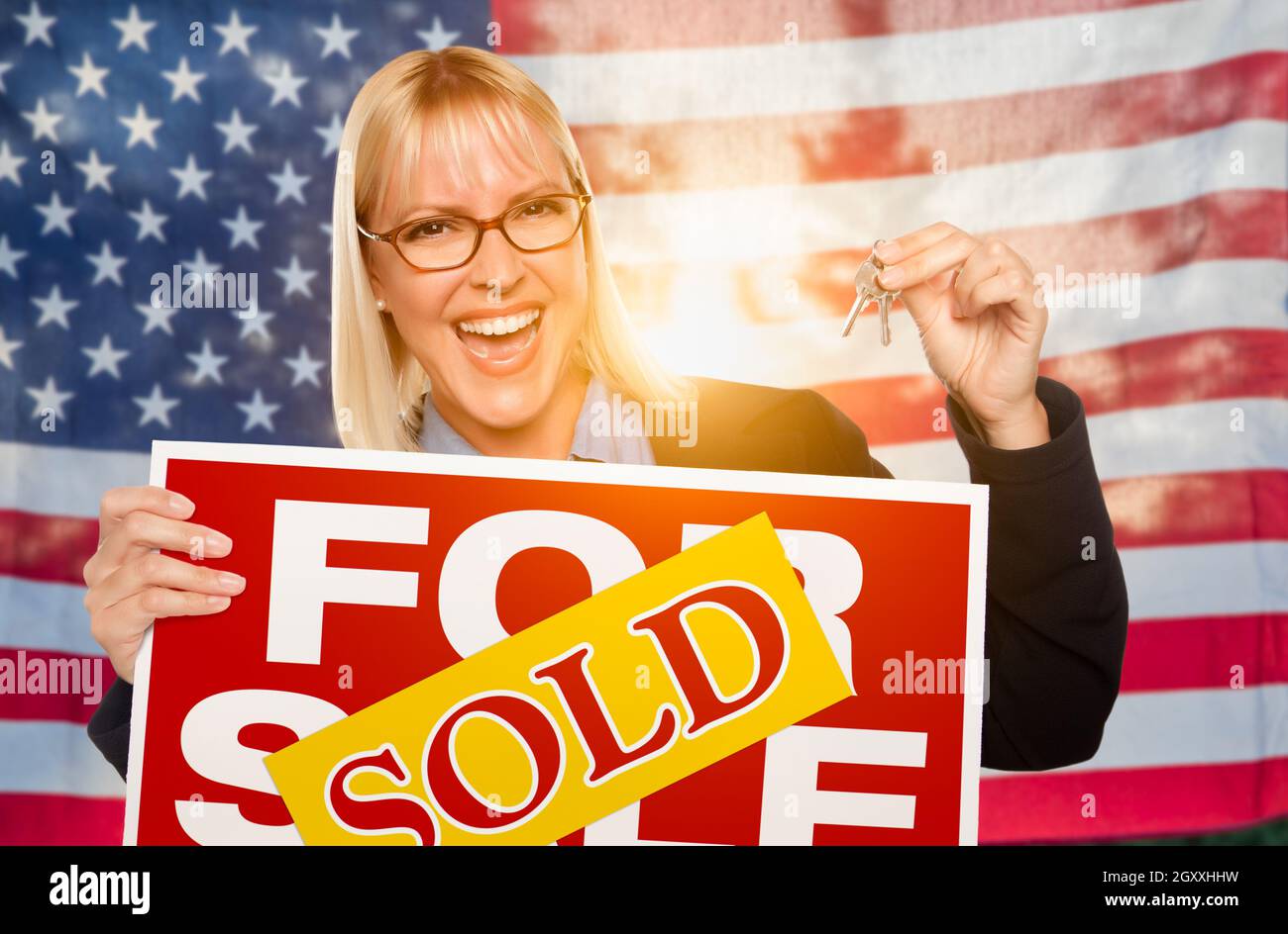 Young Woman Holding House Keys and Sold Sign In Front of American Flag ...