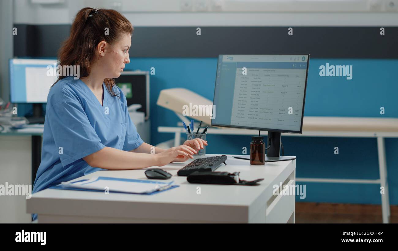 Nurse typing on computer keyboard for consultation and appointment ...