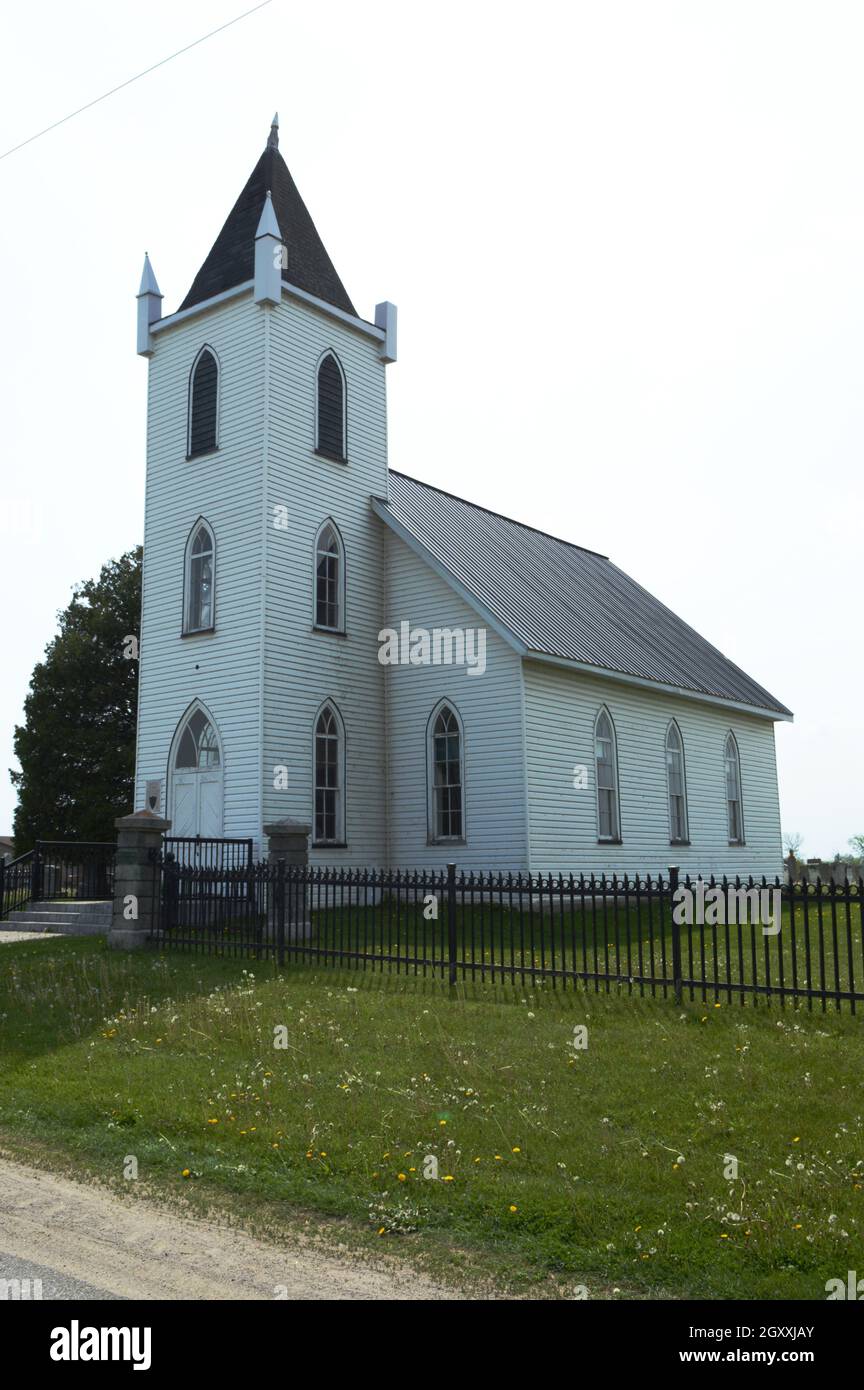 A beautiful white Church exterior on a grass and sky environment during ...