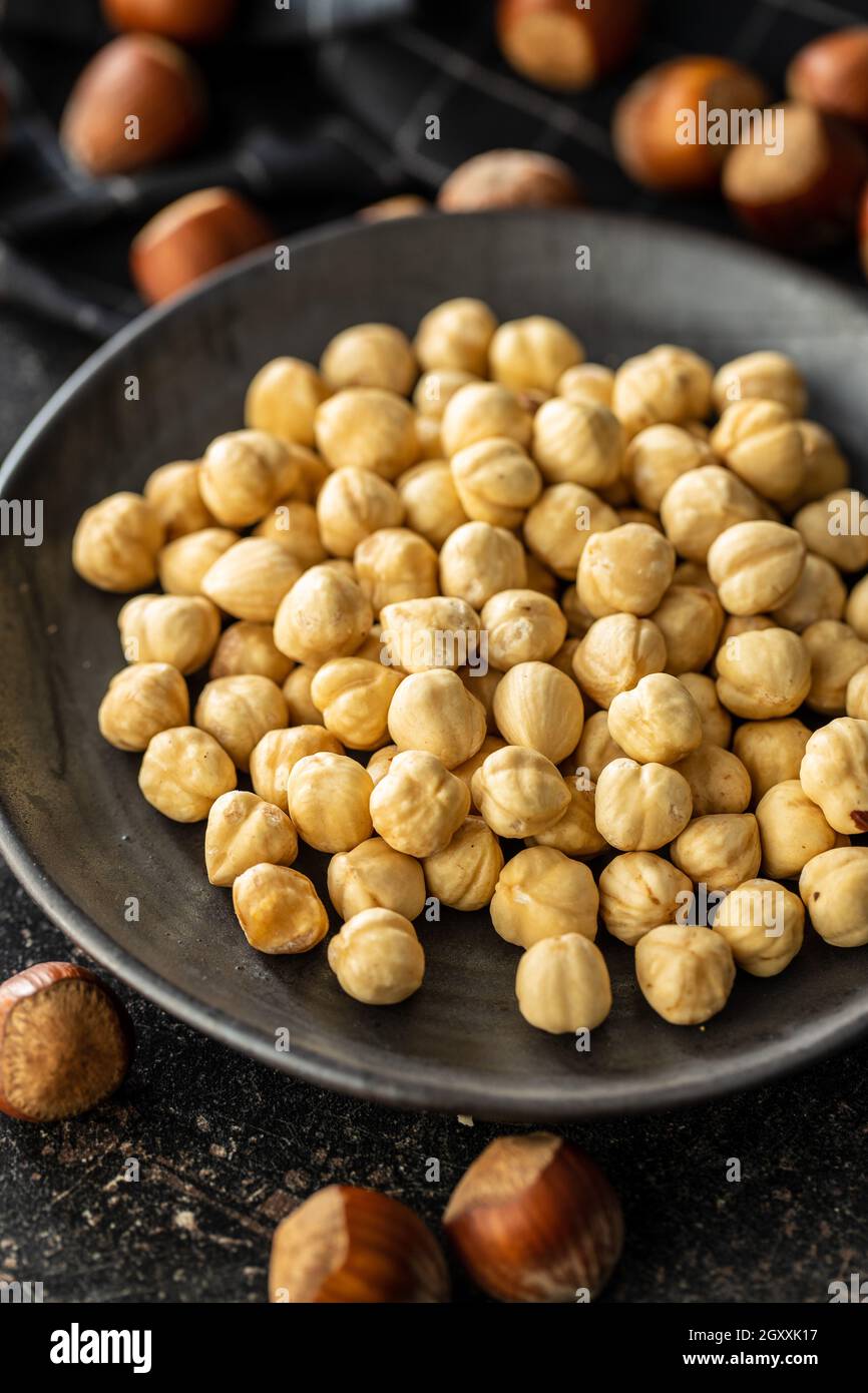 Peeled roasted hazelnut kernels in black plate Stock Photo - Alamy