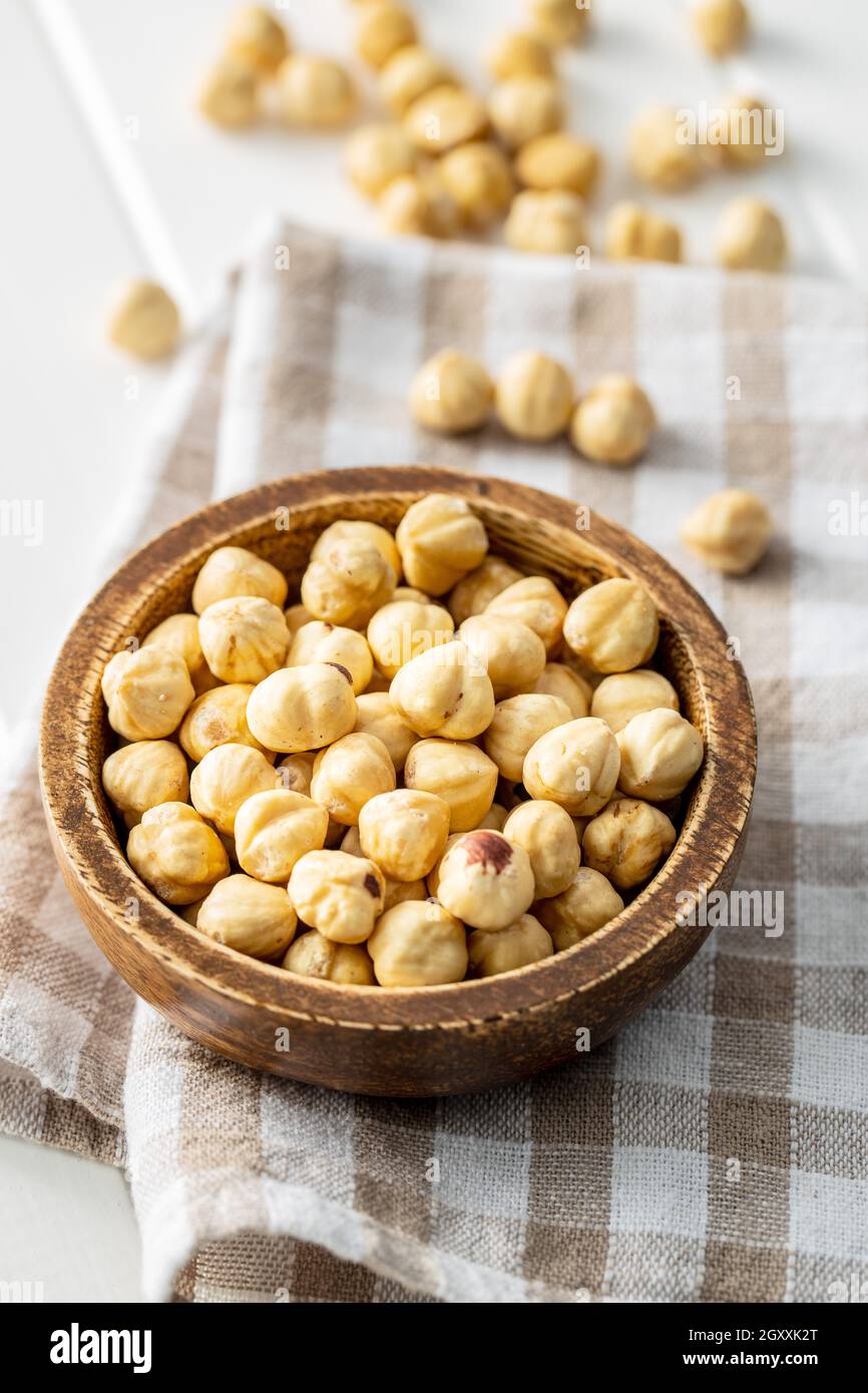 Peeled roasted hazelnut kernels in wooden bowl Stock Photo - Alamy