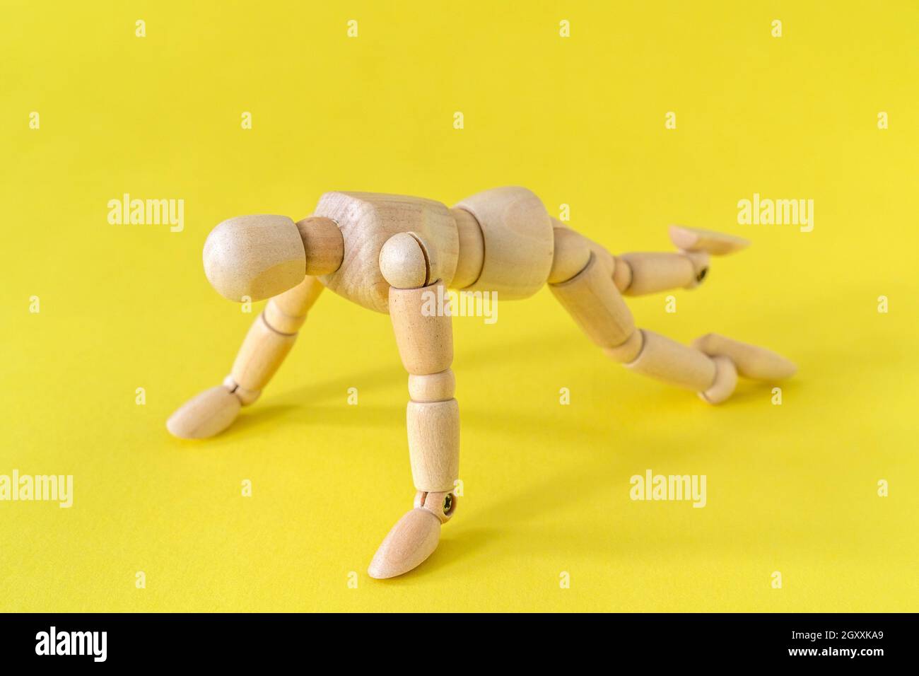 Wooden man doing push-ups on the yellow background. Healthy life ...