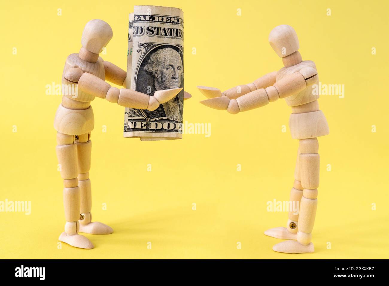Wooden man giving money to his partner, bribery and corruption concepts ...