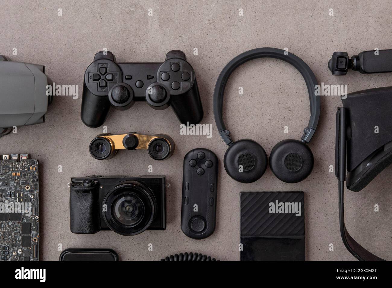 Overhead flat lay of black technology devices and gadgets on a grey ...