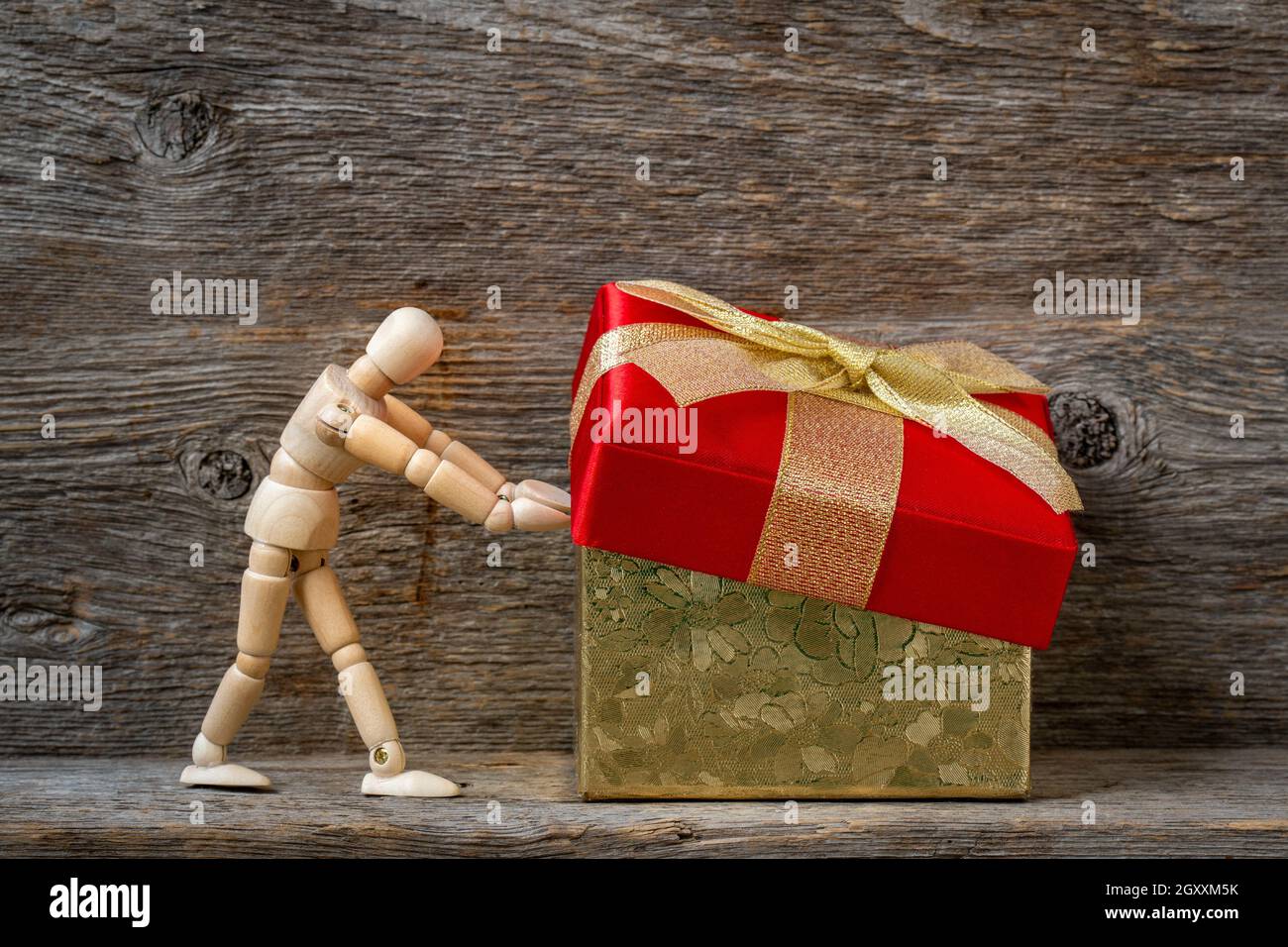 Wooden doll opening a gift box. Concept for holiday and celebration ...