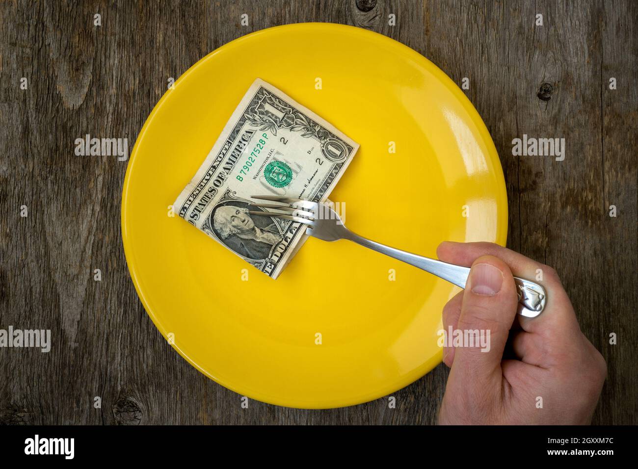 Man eating banknote, symbolising consumerism. Financial difficulties ...
