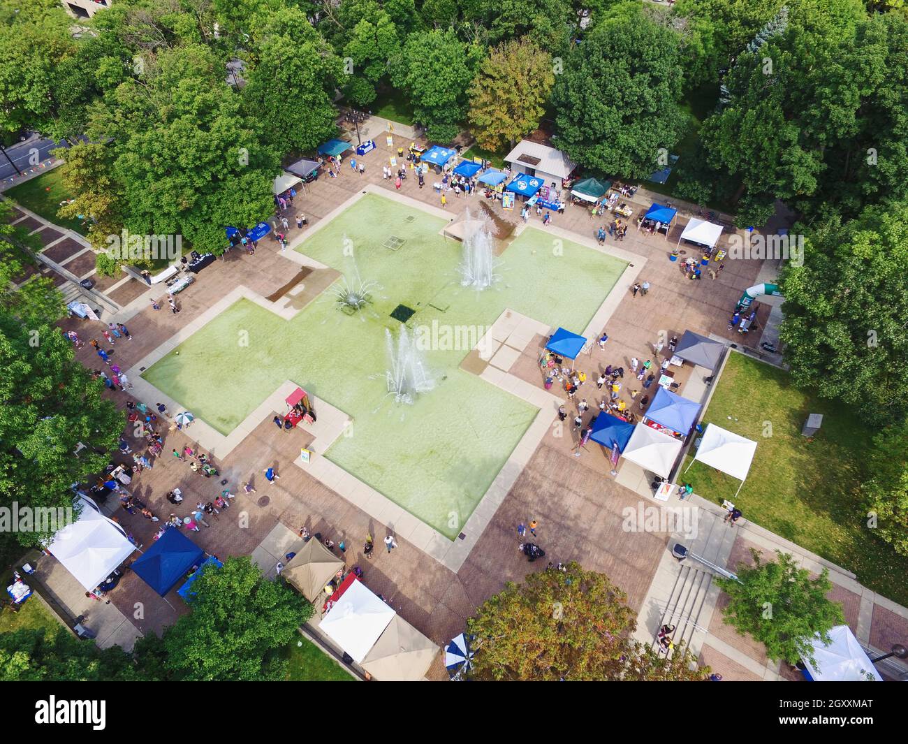 Aerial of a mini festival with a few tents surrounding a splash pad and ...