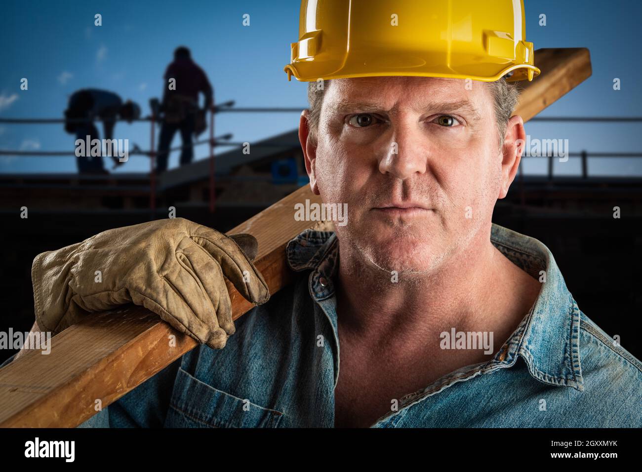 Serious Contractor in Hard Hat Carrying Wood Plank At Construction Site ...