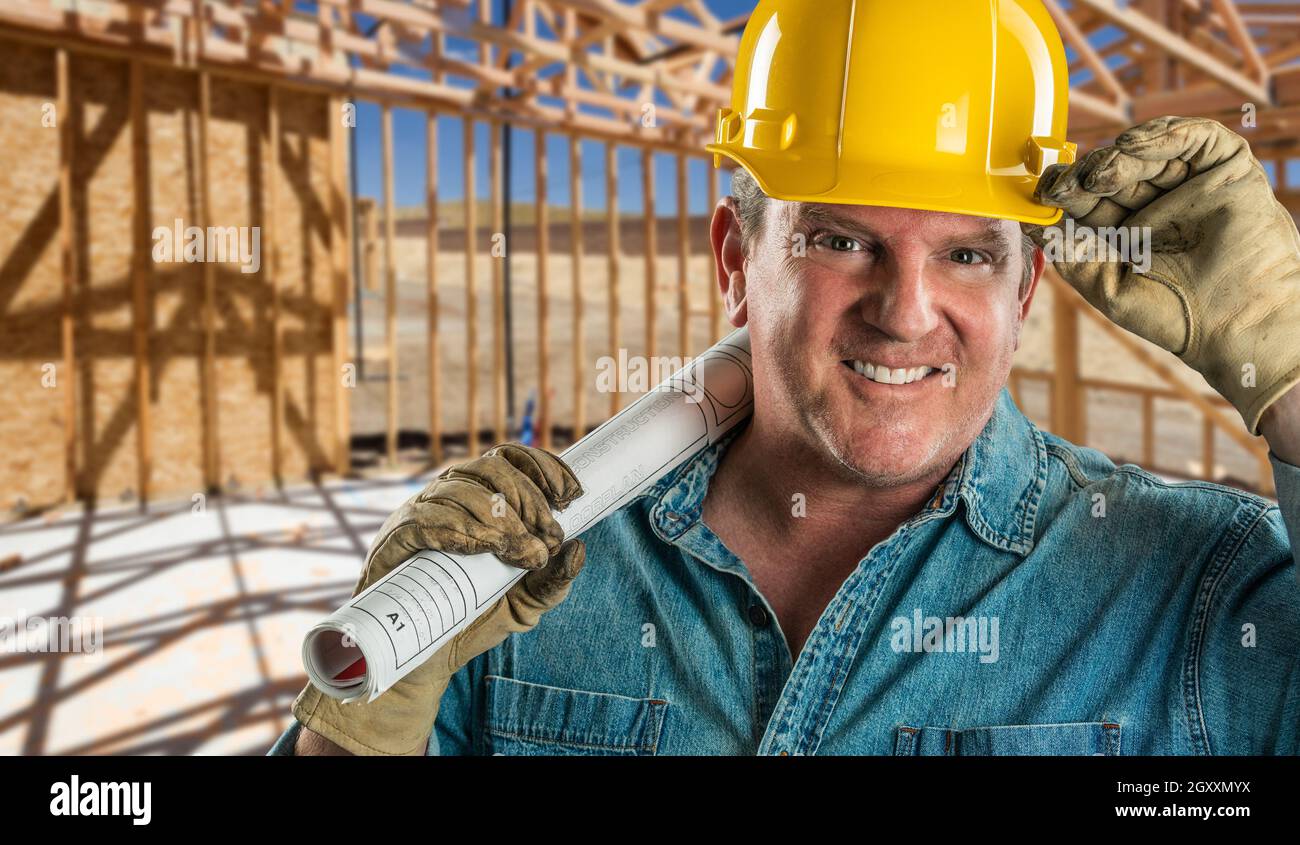 Smiling Contractor in Hard Hat Holding Floor Plans At Construction Site ...