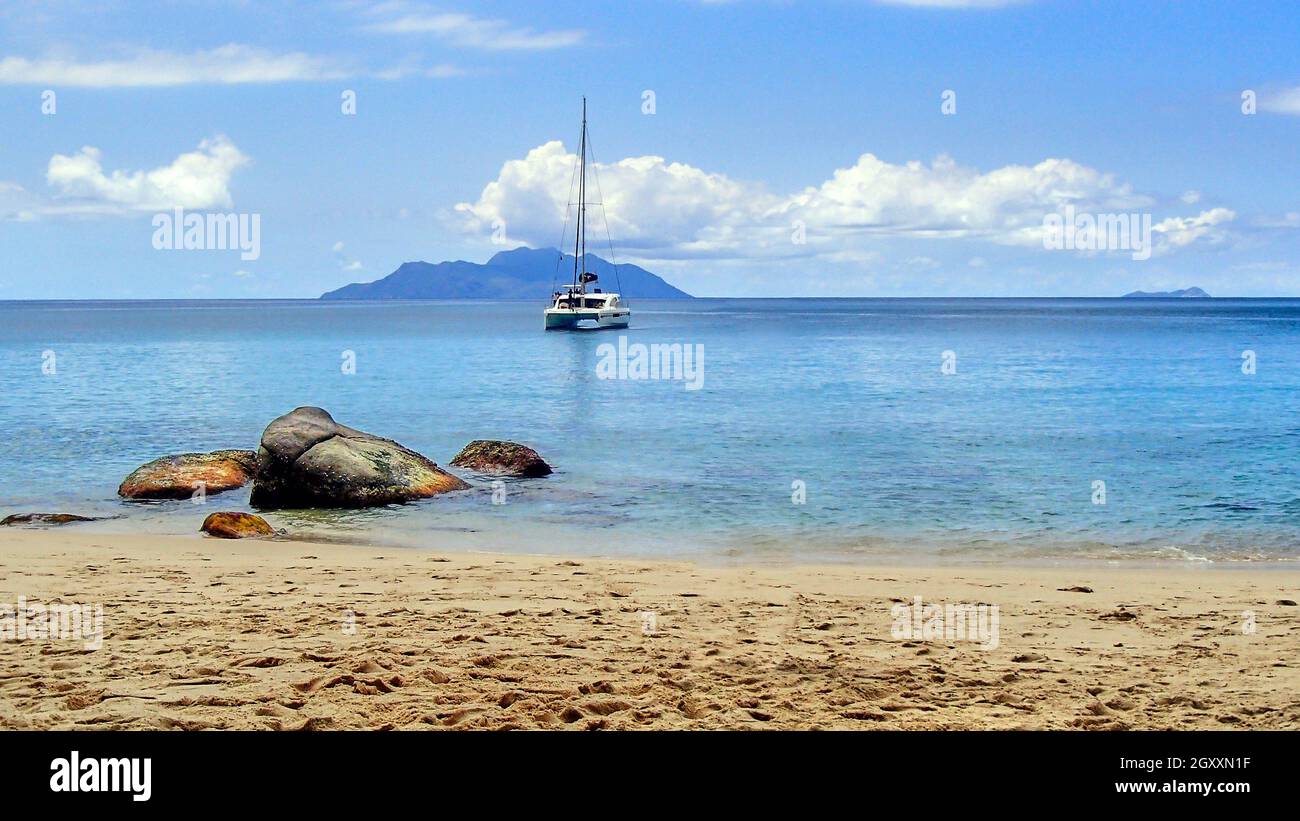 A lonely white catamaran is anchored in the turquoise blue water in ...