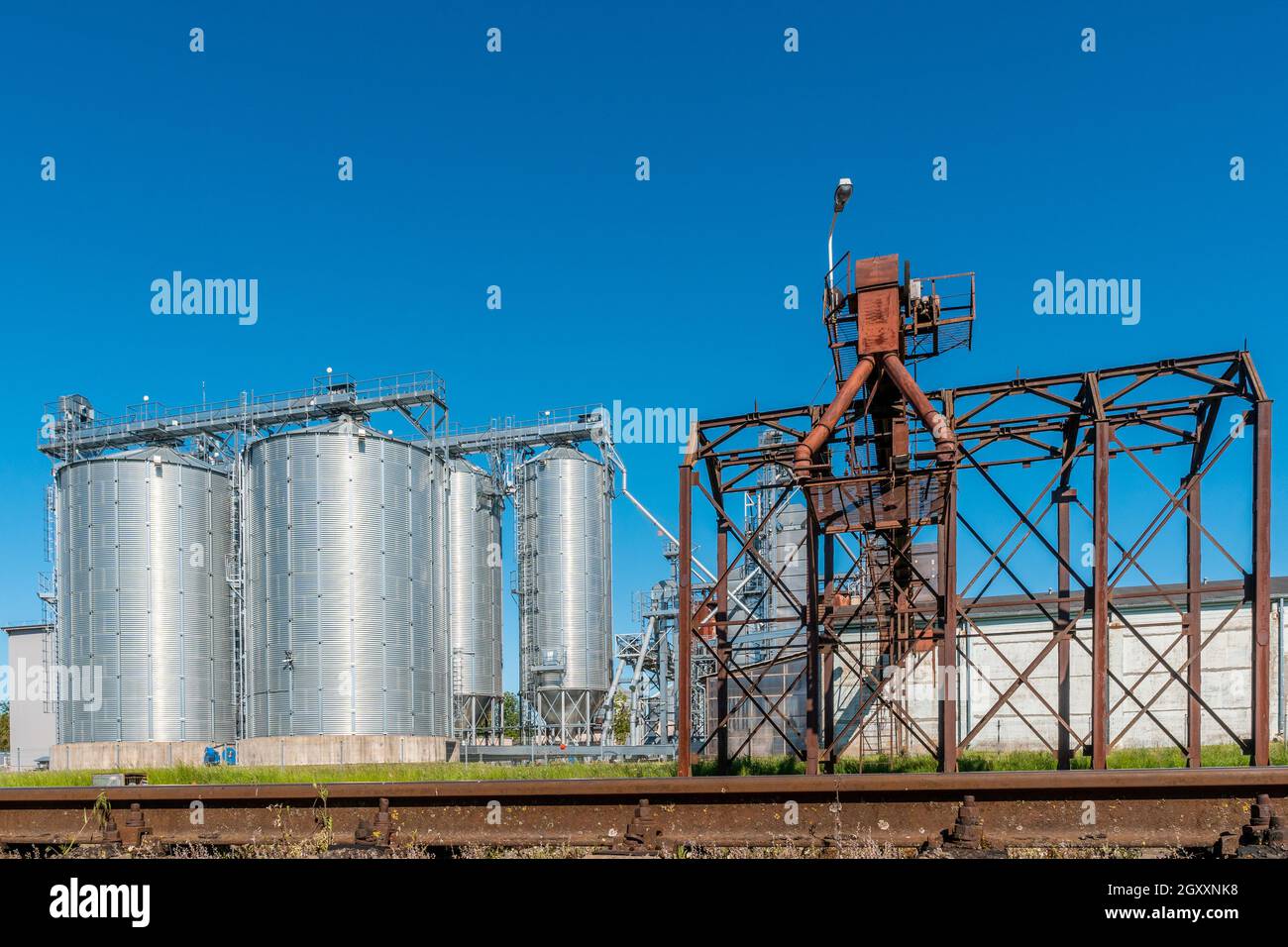 Round metal grain elevator bins next to railroad tracks Stock Photo - Alamy