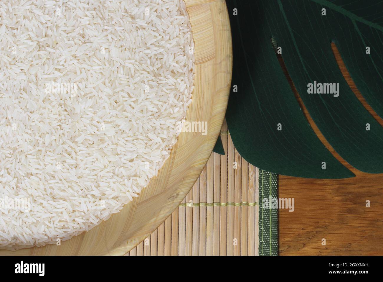 Bowl of Uncooked White Rice with leaf on bamboo mat Stock Photo - Alamy