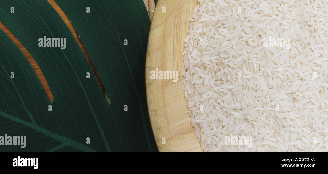 Bowl of Uncooked White Rice with leaf on bamboo mat Stock Photo - Alamy