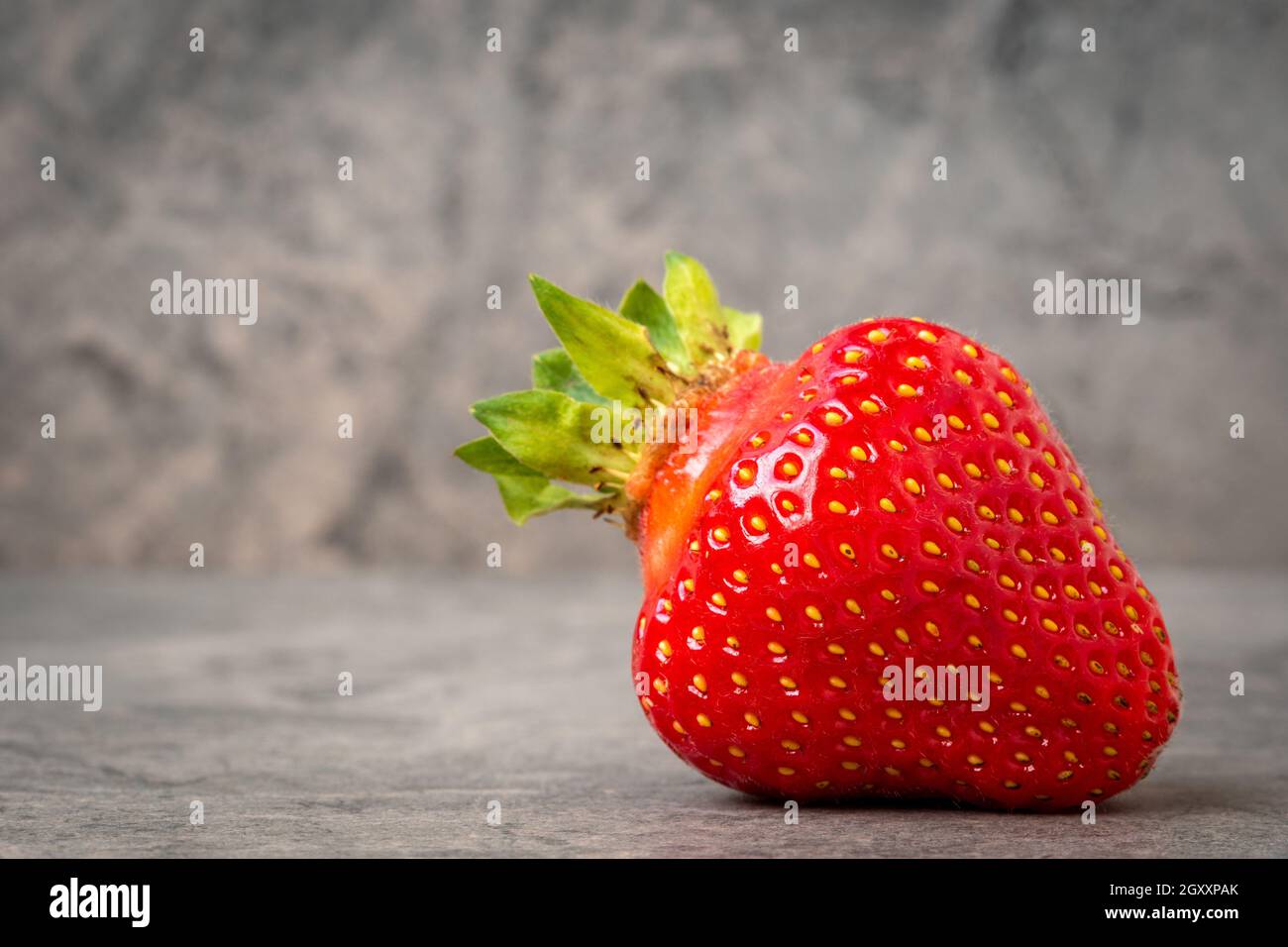 Red berry strawberry lying on grey stone background Stock Photo - Alamy