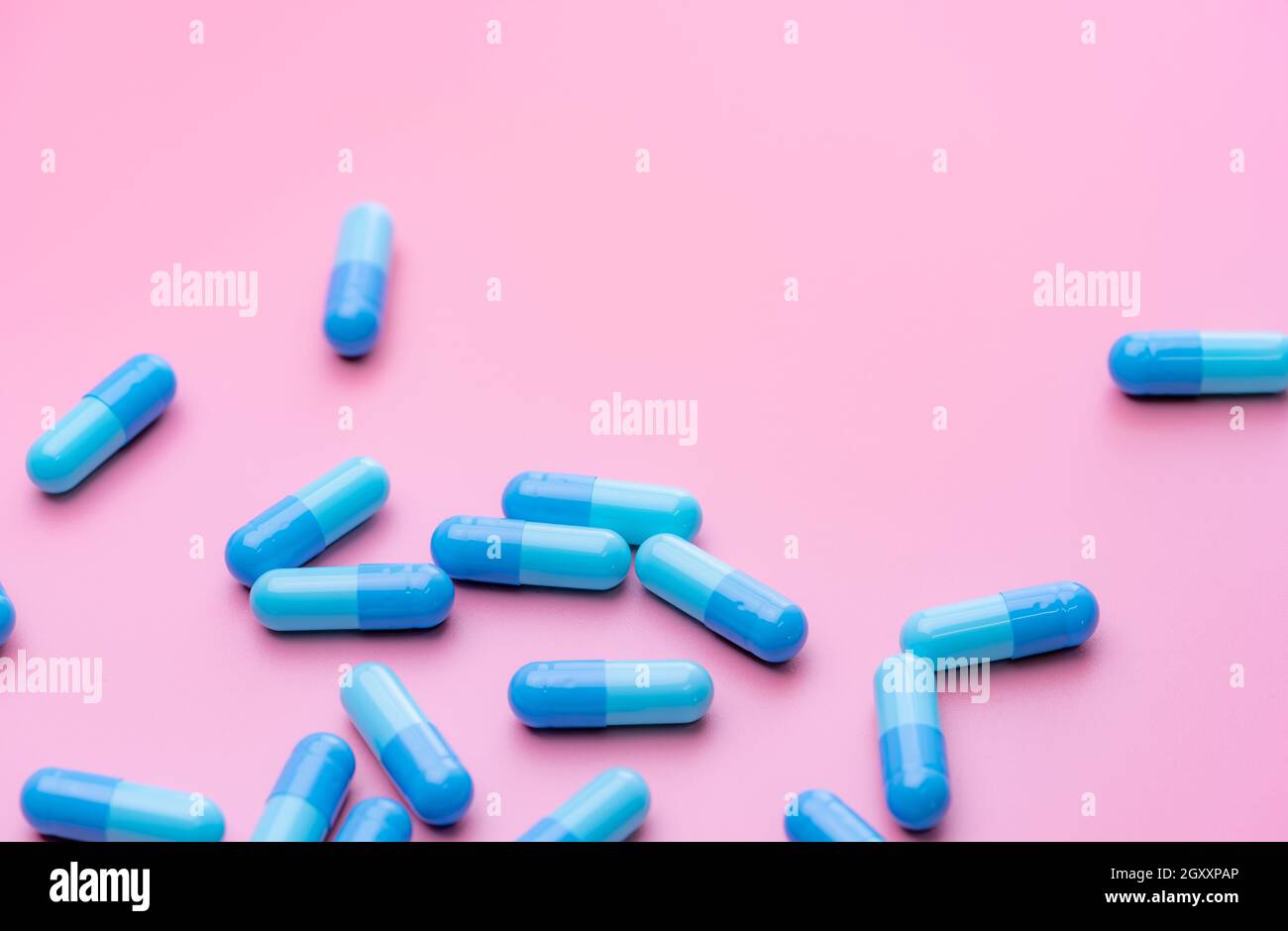 Blue capsule pills on pink background. Online pharmacy banner. Group of ...