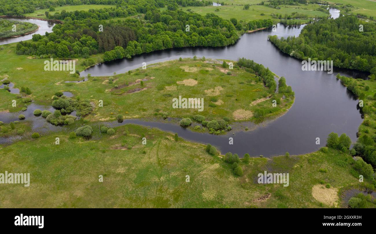 Aerial view of winding river bed with ducts. Flying above swampy plain ...