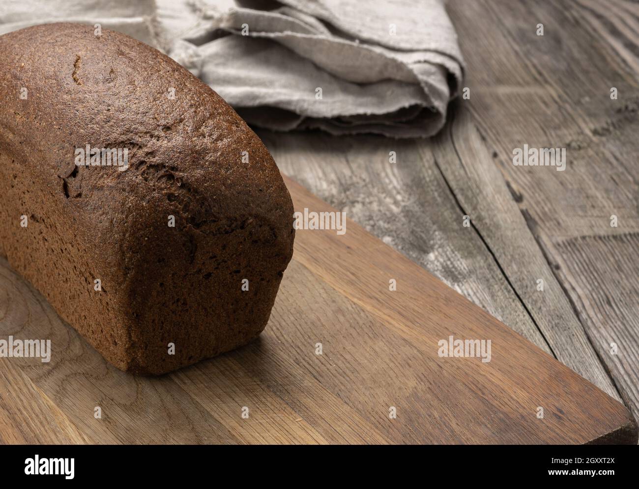 baked rectangular rye flour bread on brown board, healthy food Stock ...