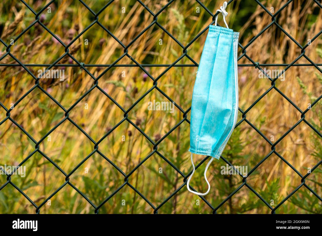 Coronavirus quarantine. Medical mask on mesh wire fence. Global ...