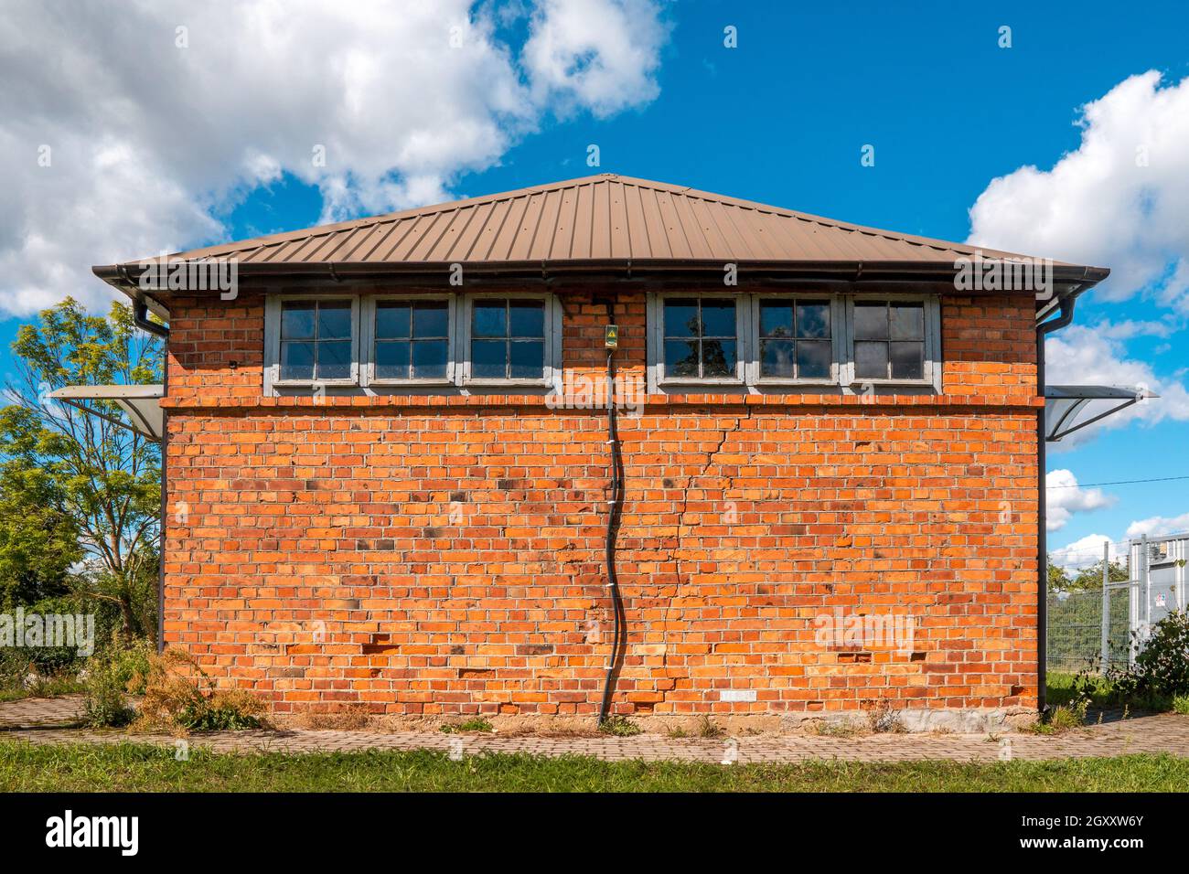 Abandoned small old red bricks building with cracked facade and six wooden frame windows Stock ...