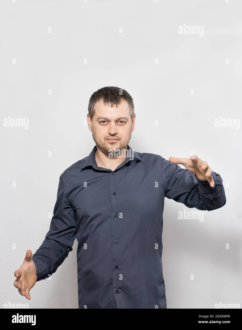 The man holds an invisible ball with his hands, one hand up the other ...