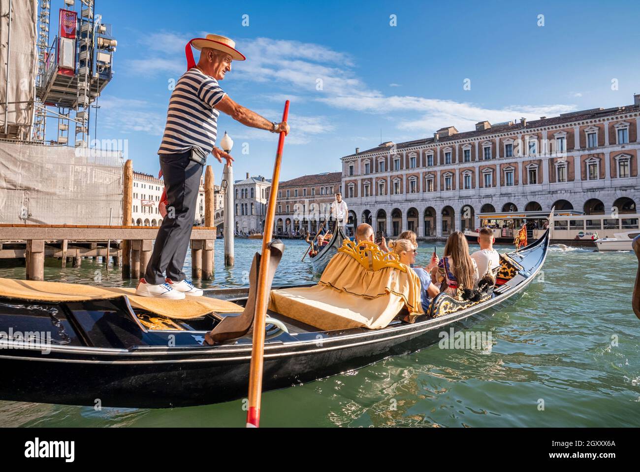 Venetian gondolier punting gondola through Grand canal Stock Photo - Alamy