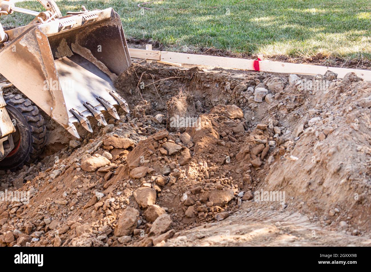 Small Bulldozer Digging In Yard For Pool Installation Stock Photo - Alamy