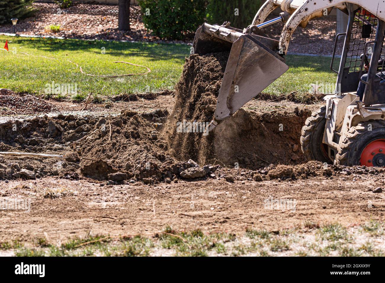 Small Bulldozer Digging In Yard For Pool Installation Stock Photo - Alamy