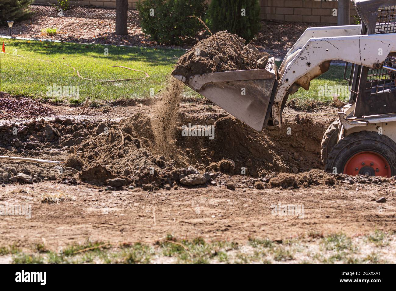 Small Bulldozer Digging In Yard For Pool Installation Stock Photo - Alamy