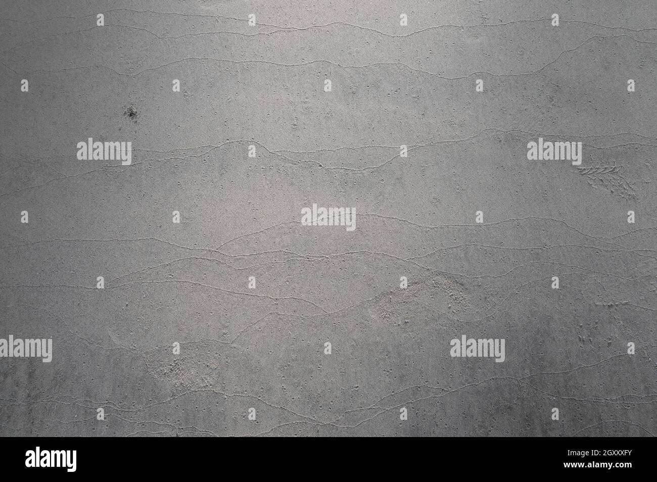Grey abstract background of wet sand texture occured by sea waves on ...