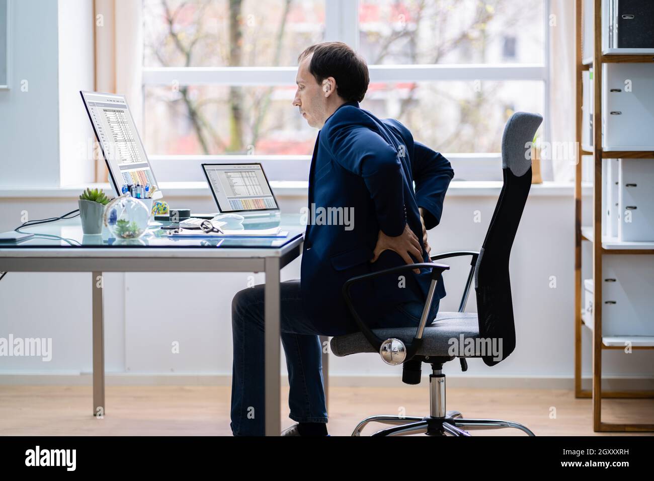 Bad Posture Back Pain In Office Chair Stock Photo - Alamy