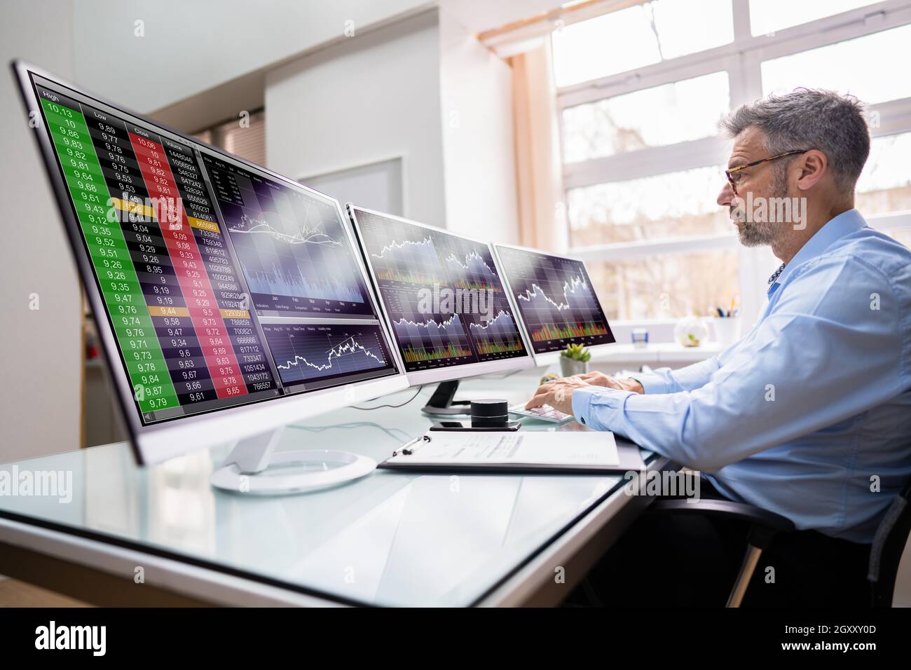 Stock Exchange Analyst Using Multiple Computer Screens Stock Photo - Alamy