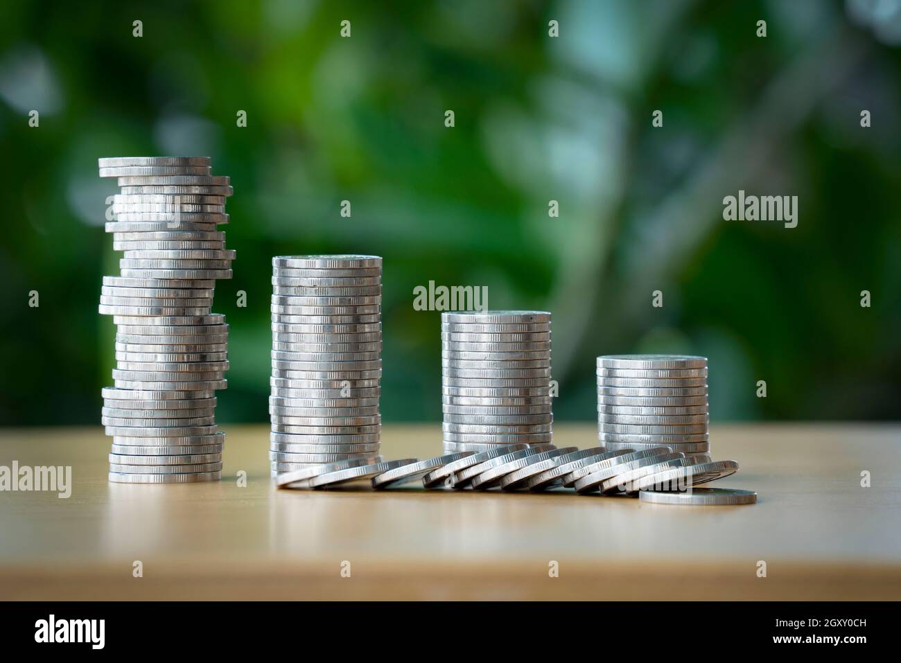 A pile of coins break down. Mini wooden house and row of coin falls ...